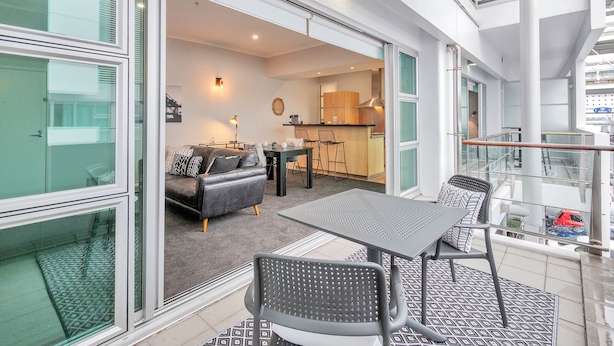 Um apartamento moderno com varanda, área de refeições e cozinha.