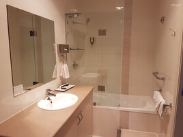 Casa de banho moderna com lavatório, espelho e cabine de duche em vidro.