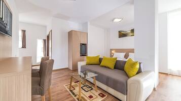 Uma sala de estar moderna com um sofá, mesa de centro e uma TV.