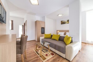 Uma sala de estar moderna com um sofá, mesa de centro e uma TV.