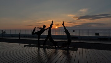 Vista do pôr do sol a partir de um deck de madeira com guarda-corpo.