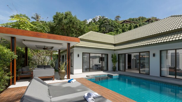 Uma casa moderna com piscina, deck de madeira e área de estar coberta ao ar livre.