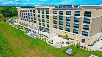 Hotel com vários andares, pátio central, área de estar ao ar livre e jardim ajardinado.