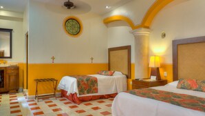 Quarto de hotel com duas camas, penteadeira de madeira, espelho e ventoinha no teto.