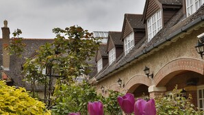 Um edifício tradicional com fachada de tijolo, janelas em arco e um janela saliente.