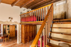 Um interior rústico com uma escadaria de madeira, área de jantar e cozinha.