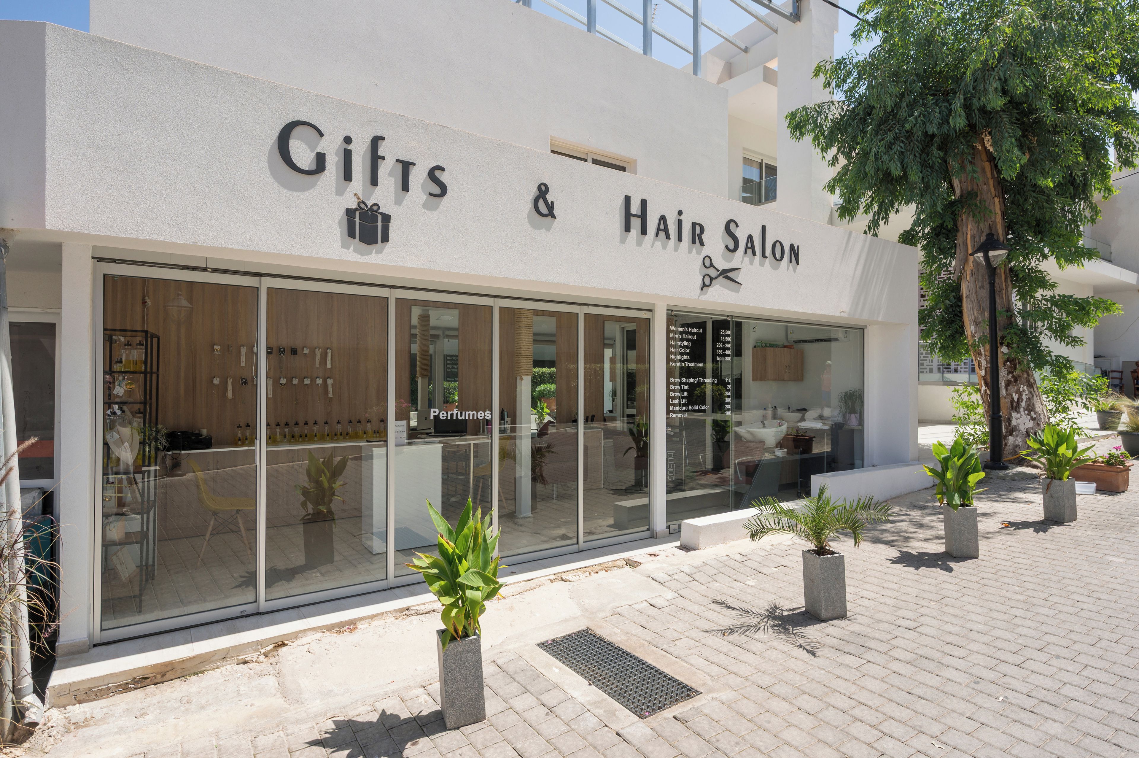 Fachada de loja com placa indicando 'Gifts & Hair Salon'.