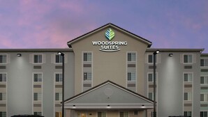 Um hotel com vários andares e um logotipo bem visível no topo.