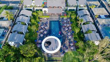 Vista aérea de um resort com vários edifícios, uma piscina central e áreas de estar ao ar livre.