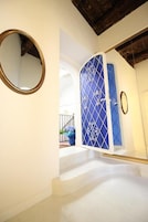 Uma escada com paredes brancas e um painel decorativo azul.