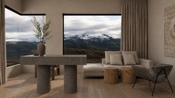 Uma sala de estar moderna com uma janela grande, um sofá, uma mesa de centro e um vaso decorativo.