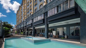 Um hotel com piscina, área de estar ao ar livre e espaço coberto.
