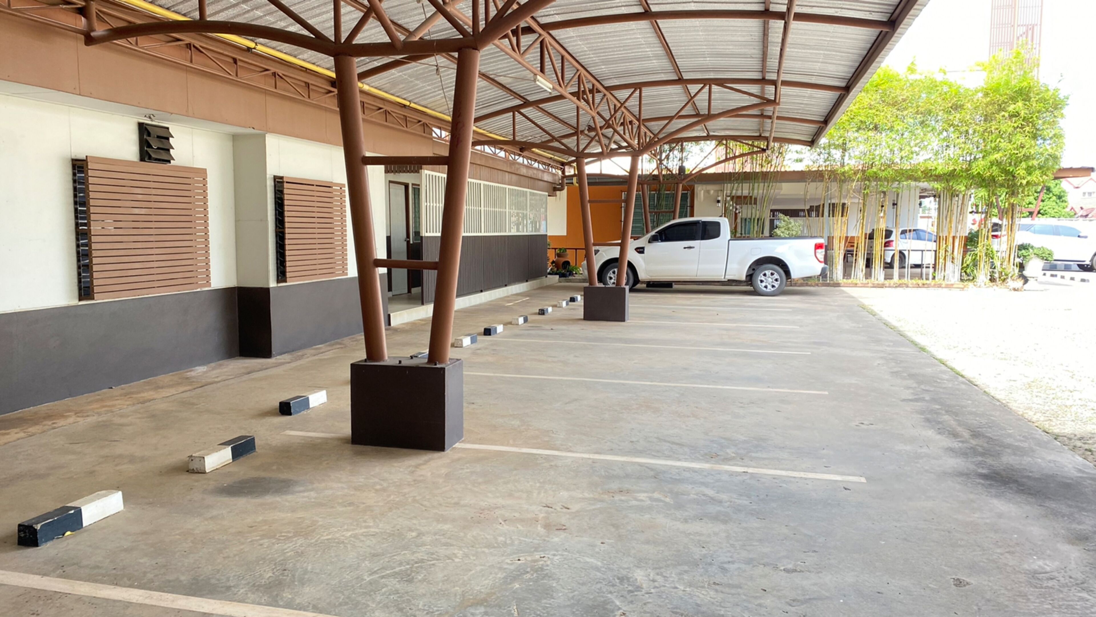 Uma área de estacionamento coberta com uma caminhonete branca estacionada dentro.