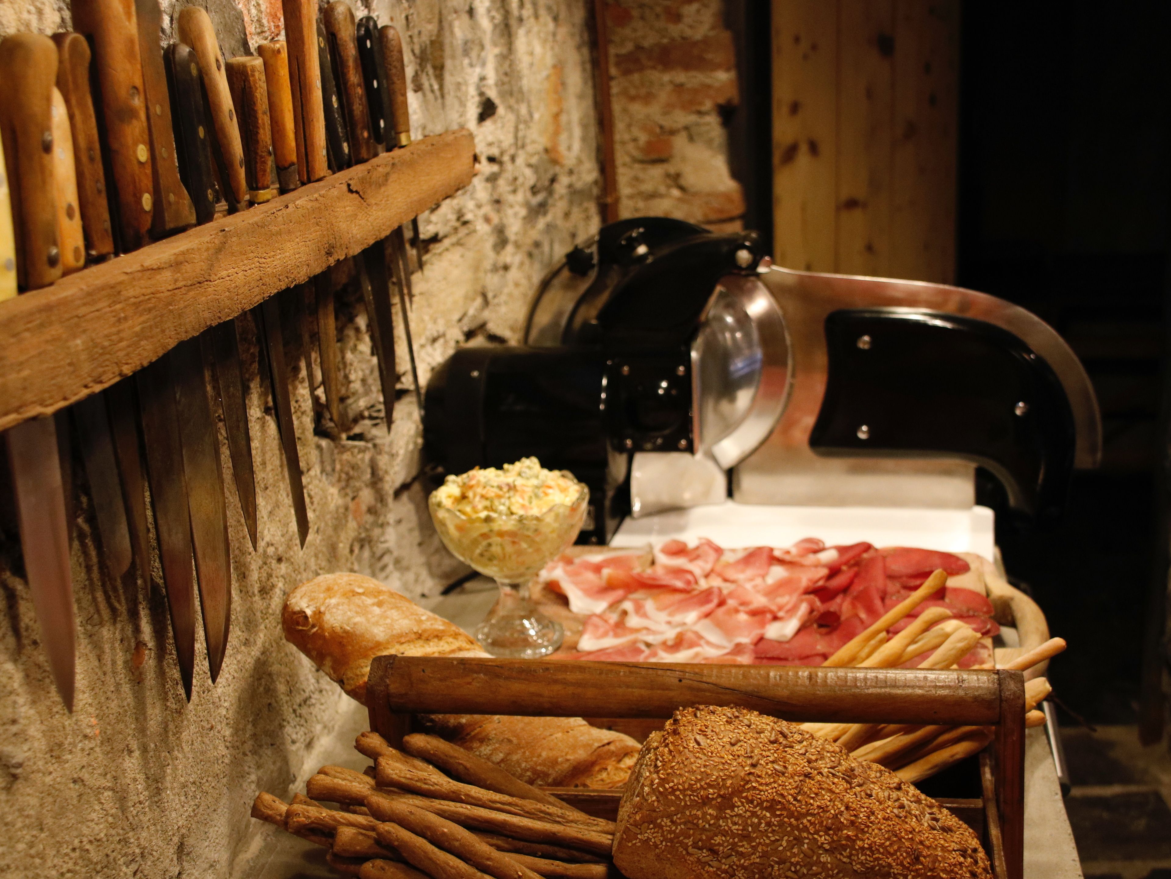 Uma bancada de cozinha com diversos alimentos, incluindo pão, carne e uma saladeira.