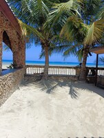 Na praia, praia de areia branca, guarda-sóis de praia, toalhas de praia