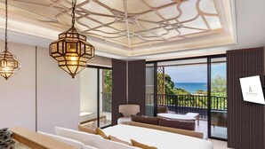 Quarto moderno com uma cama grande, varanda com vista para o mar e duas luminárias pendentes.