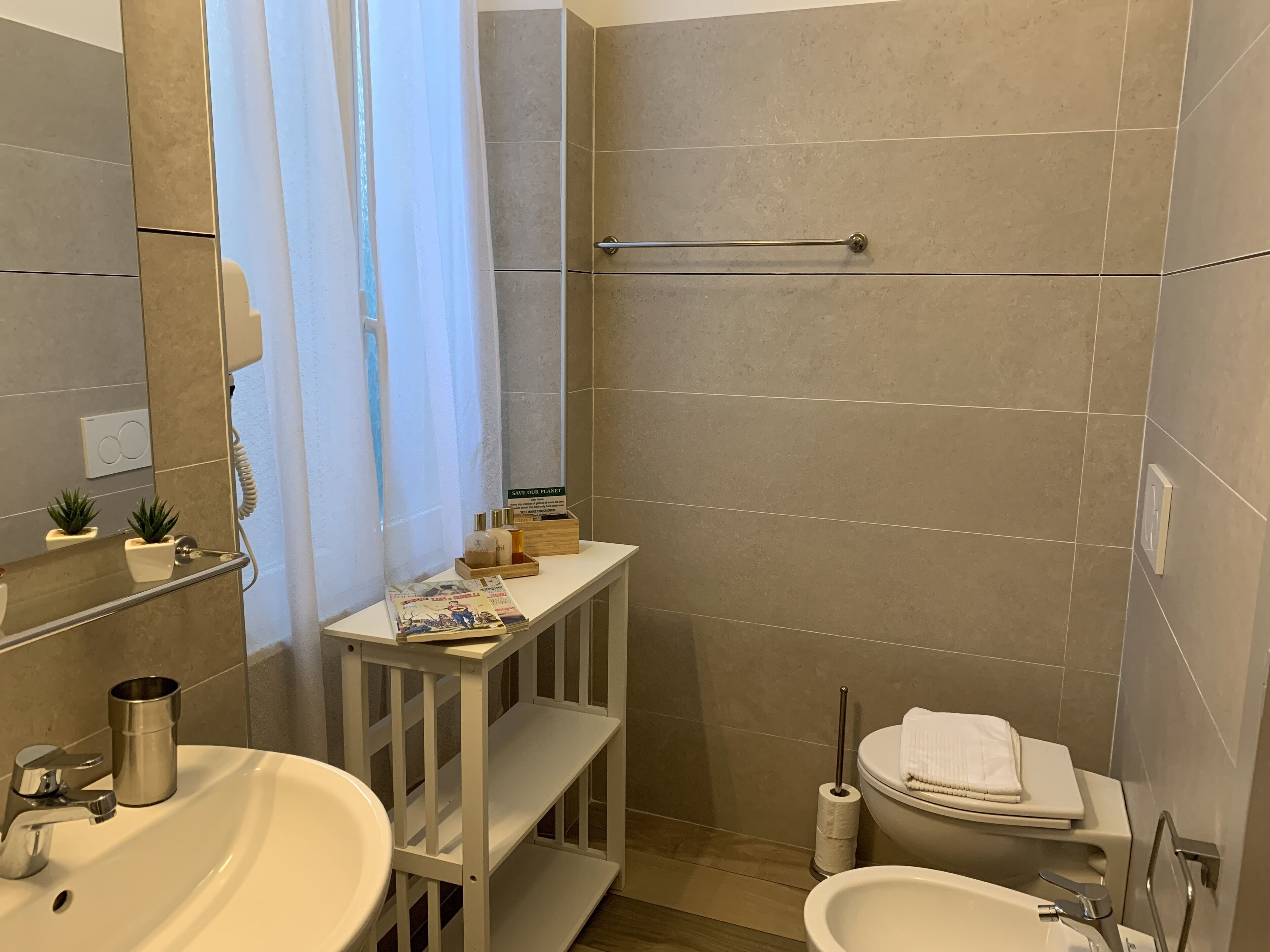 Um banheiro moderno com toucador, duas pias, área de chuveiro e vaso sanitário.
