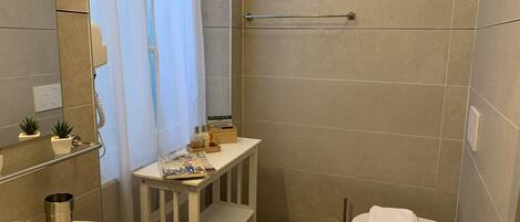 Um banheiro moderno com toucador, duas pias, área de chuveiro e vaso sanitário.