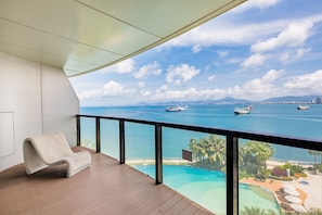 Uma varanda moderna com vista para o mar e uma área de piscina.