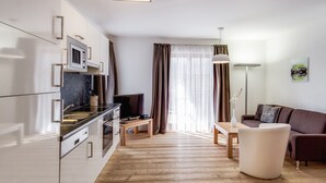 Um apartamento moderno com cozinha, sala de estar e mesa de jantar.