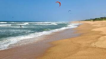 Uma praia com areal e ondas do oceano.