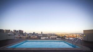 Piscina no terraço com vista para a paisagem urbana, incluindo uma ponte e edifícios altos.