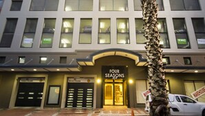Um hotel com vários andares e fachada moderna, com uma entrada destacada e a placa 'FOUR SEASONS'.