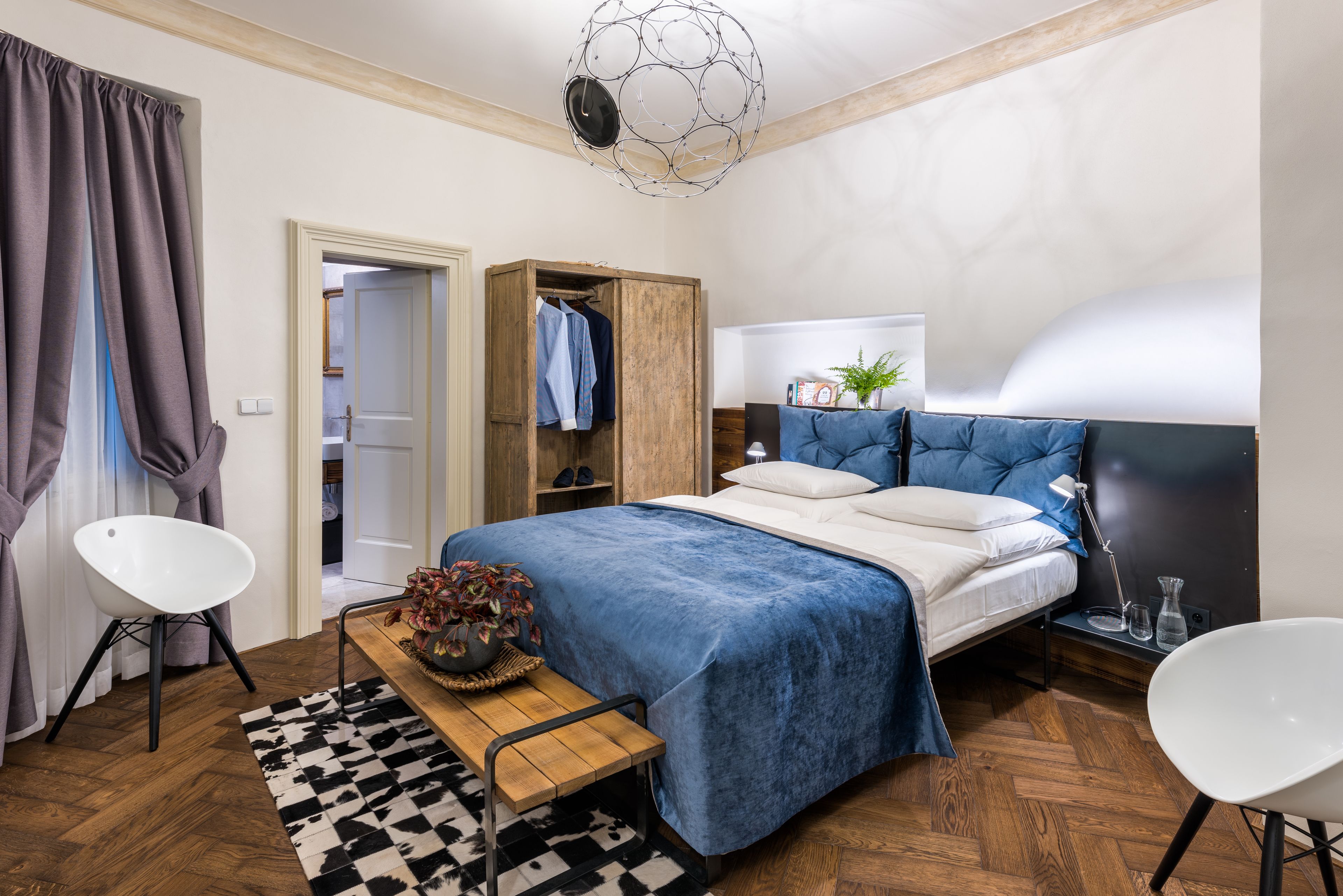 Quarto moderno com cama, guarda-roupa de madeira, escrivaninha e uma cadeira.