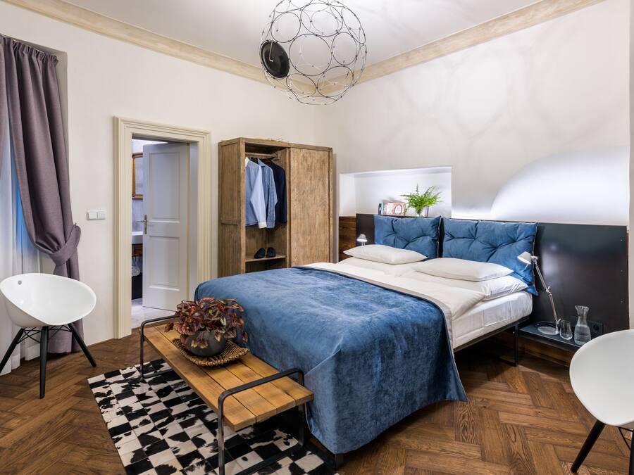 Quarto moderno com cama, guarda-roupa de madeira, escrivaninha e uma cadeira.