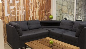 Uma sala de estar moderna com um sofá seccional, uma mesa de centro de madeira e uma esfera verde decorativa.