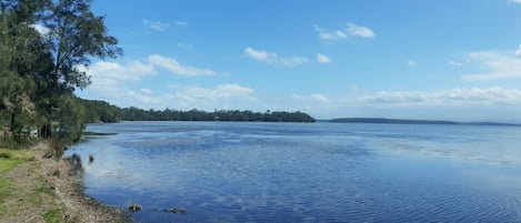 Um lago tranquilo com céu claro e terra distante.