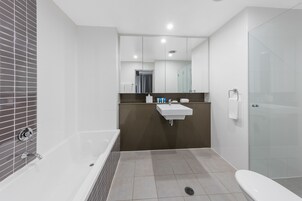 Uma casa de banho moderna com banheira, lavatório e zona de duche.