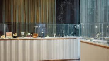 Uma área de recepção com uma vitrine de vidro contendo diversos artefatos.