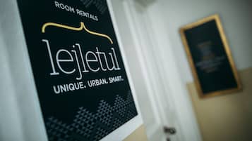 Placa com o texto 'le jeltul', 'ALUGUEL DE QUARTOS' e 'ÚNICO. URBANO. INTELIGENTE'.
