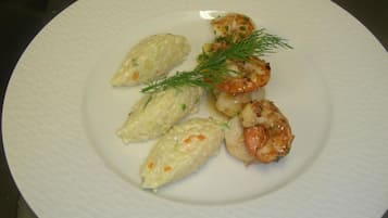 Um prato com dumplings e camarões, guarnecido com endro.