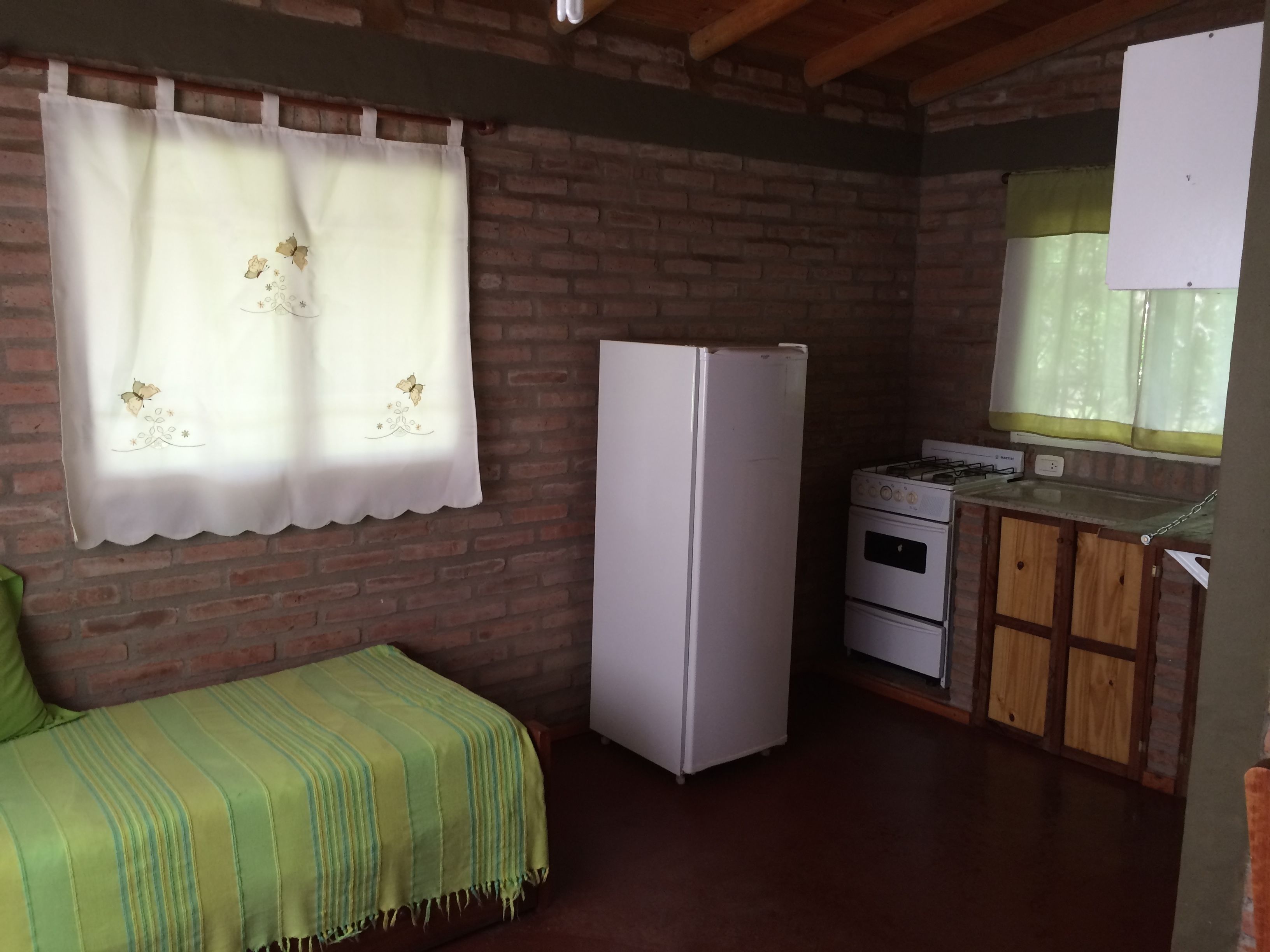 Uma cozinha compacta com geladeira, fogão e armários de madeira.