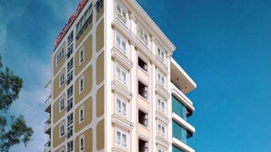 Um hotel de vários andares com entrada coberta e área de estacionamento.