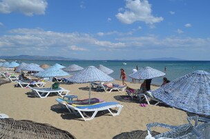 Uma praia privada, espreguiçadeiras, guarda-sóis de praia 