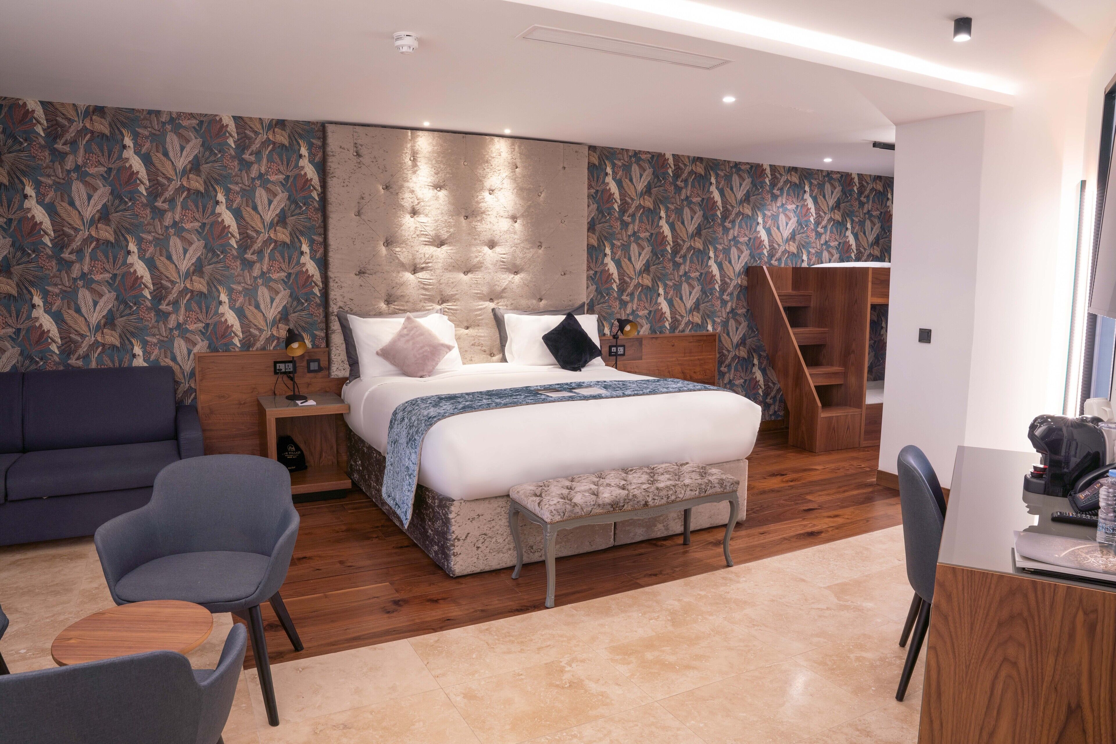 Quarto moderno com uma cama grande, um sofá, uma escrivaninha e uma cadeira.