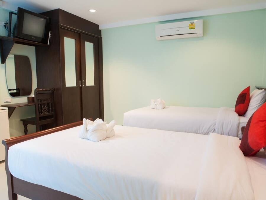 Quarto de hotel com duas camas, televisão, frigobar e ar condicionado.
