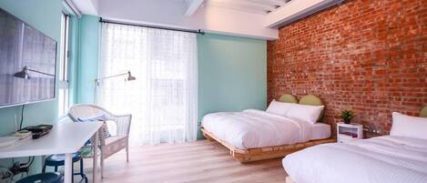 Quarto moderno com duas camas, uma escrivaninha e uma cadeira.
