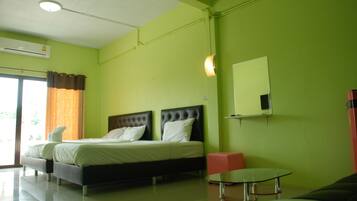 Quarto com duas camas, uma mesa de vidro e uma cadeira vermelha.