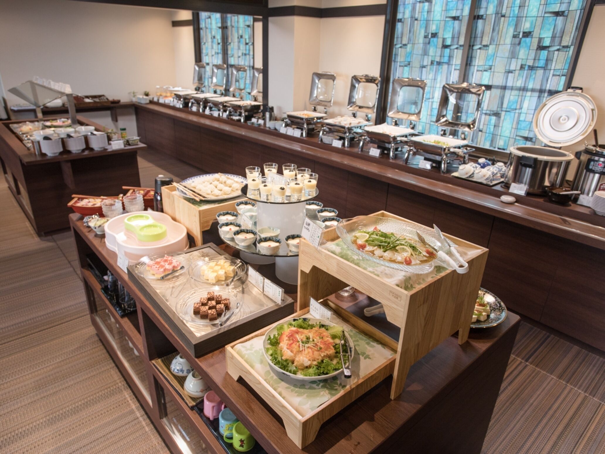 Disposição de buffet com diversos pontos de comida e uma máquina de café.