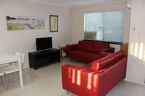 Apartamento Deluxe, 1 quarto | Sala de estar | TV de ecrã plano 