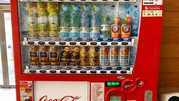 Uma máquina de vendas automática da Coca-Cola com diversas opções de bebidas, incluindo refrigerantes e energéticos.
