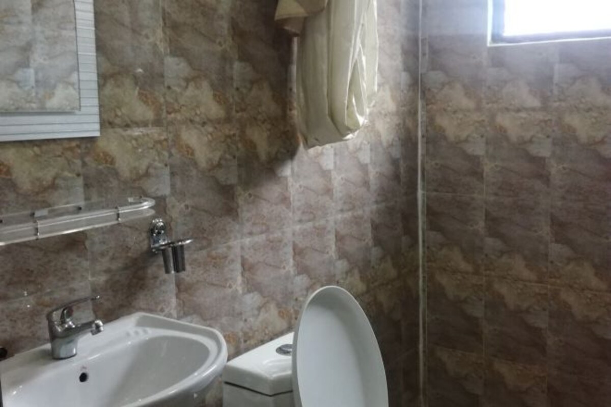 Um banheiro com pia, espelho e vaso sanitário.