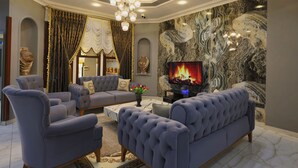 Uma sala de estar luxuosa com lareira, sofás macios e uma parede de mármore.