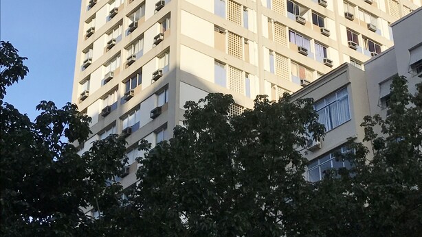 Um edifício alto e moderno, com vários andares e varandas.
