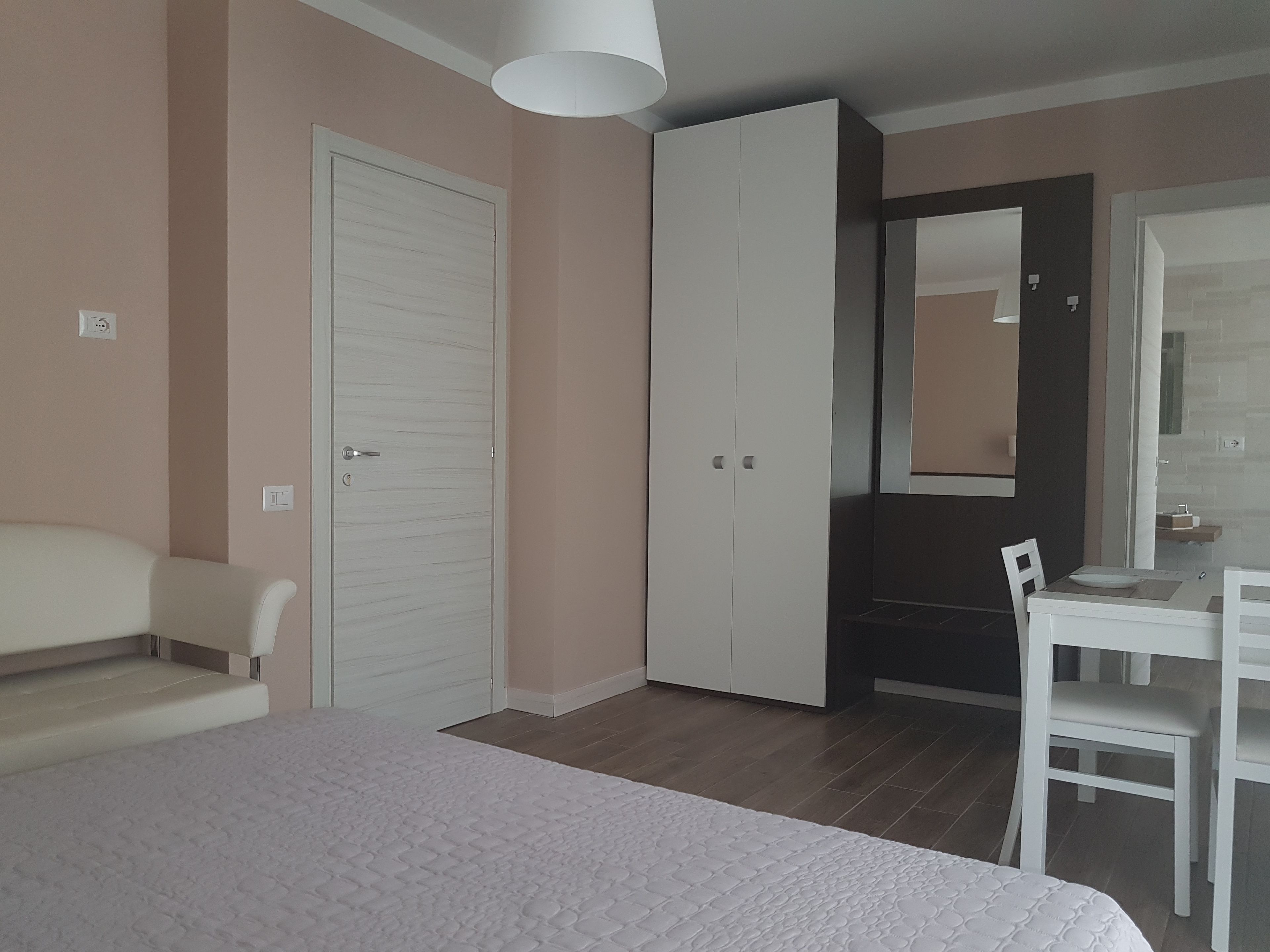 Quarto com cama, guarda-roupa, escrivaninha e cadeira.