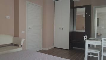 Quarto com cama, guarda-roupa, escrivaninha e cadeira.